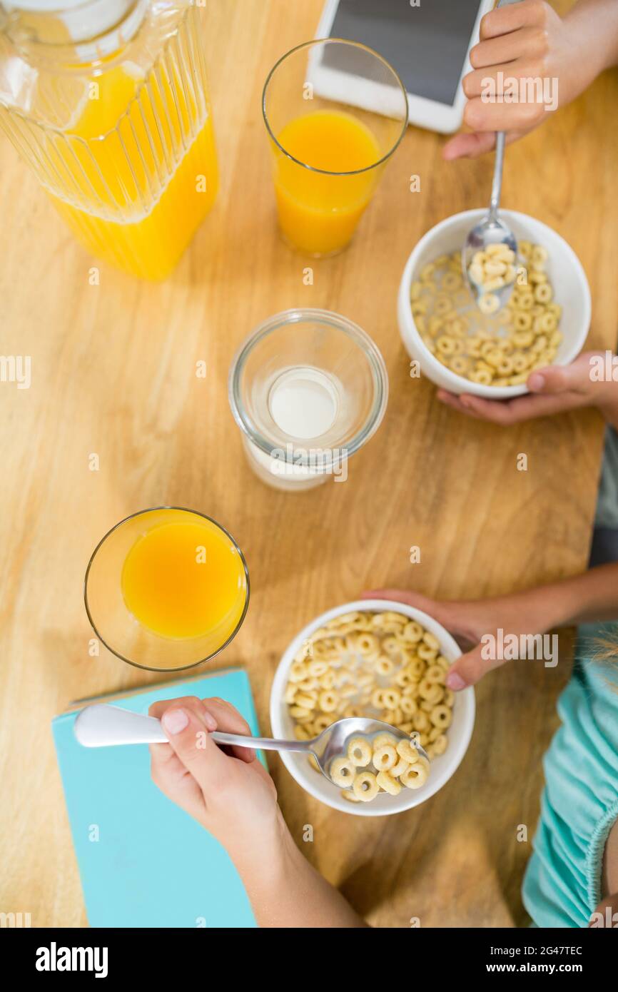 Sibling having breakfast cereal in kitchen Stock Photo - Alamy