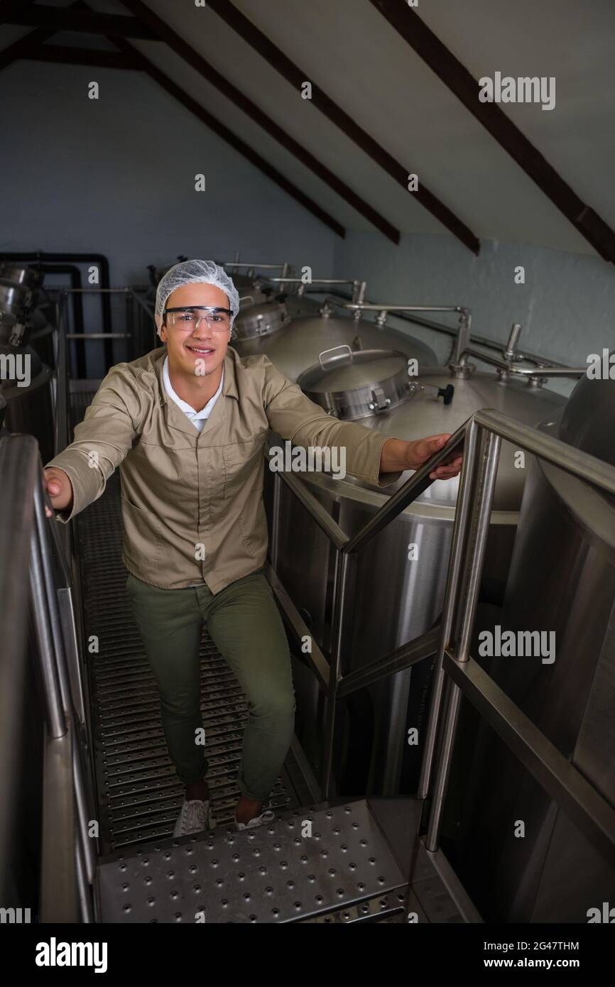 Portrait of worker standing by storage tanks on steps Stock Photo - Alamy