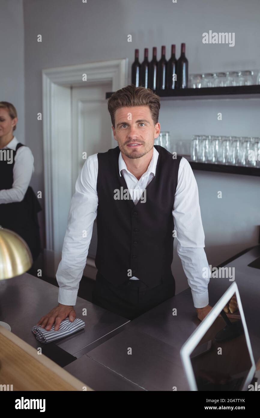 Portrait of bar tender standing at bar counter Stock Photo - Alamy
