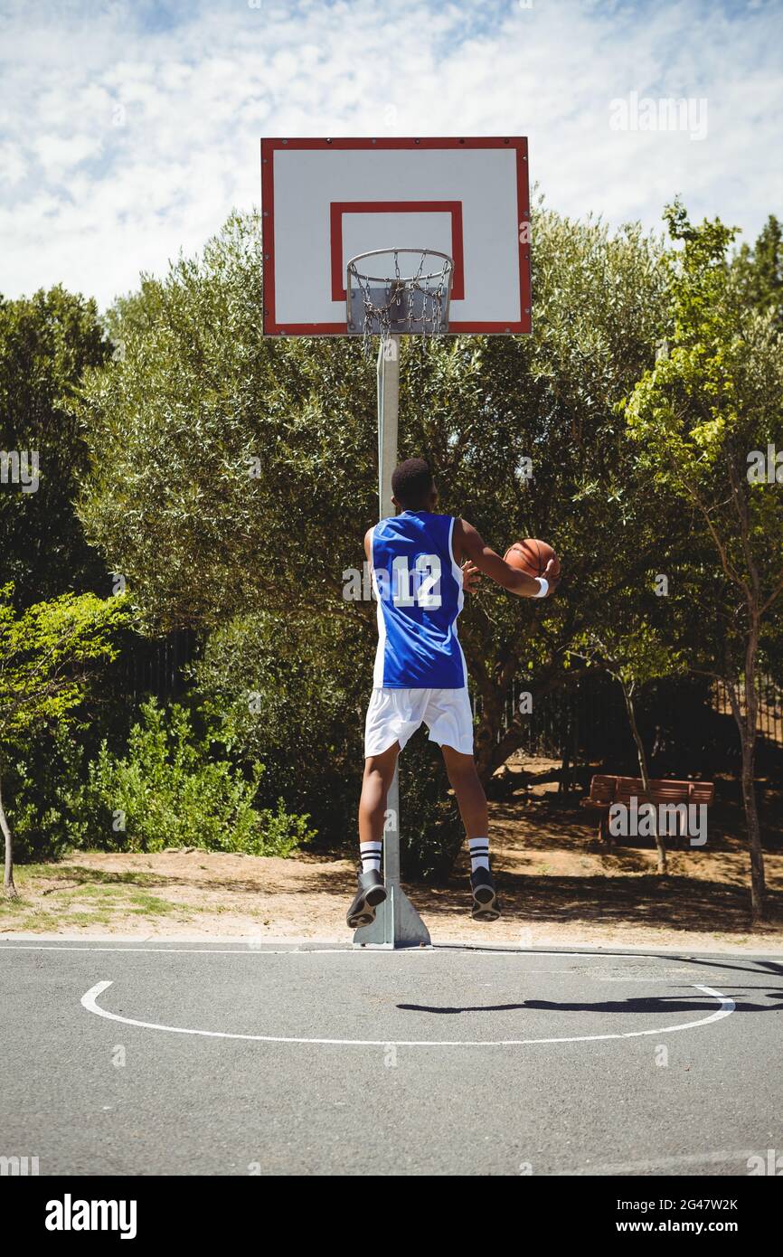 Teenage basketball player scoring while practicing at court Stock Photo ...