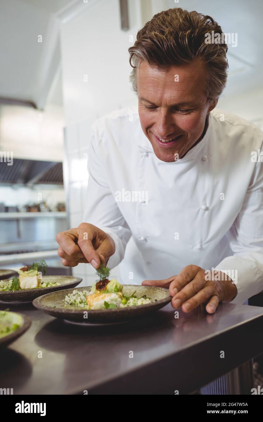 Male chef examining appetizer plates at order station Stock Photo - Alamy