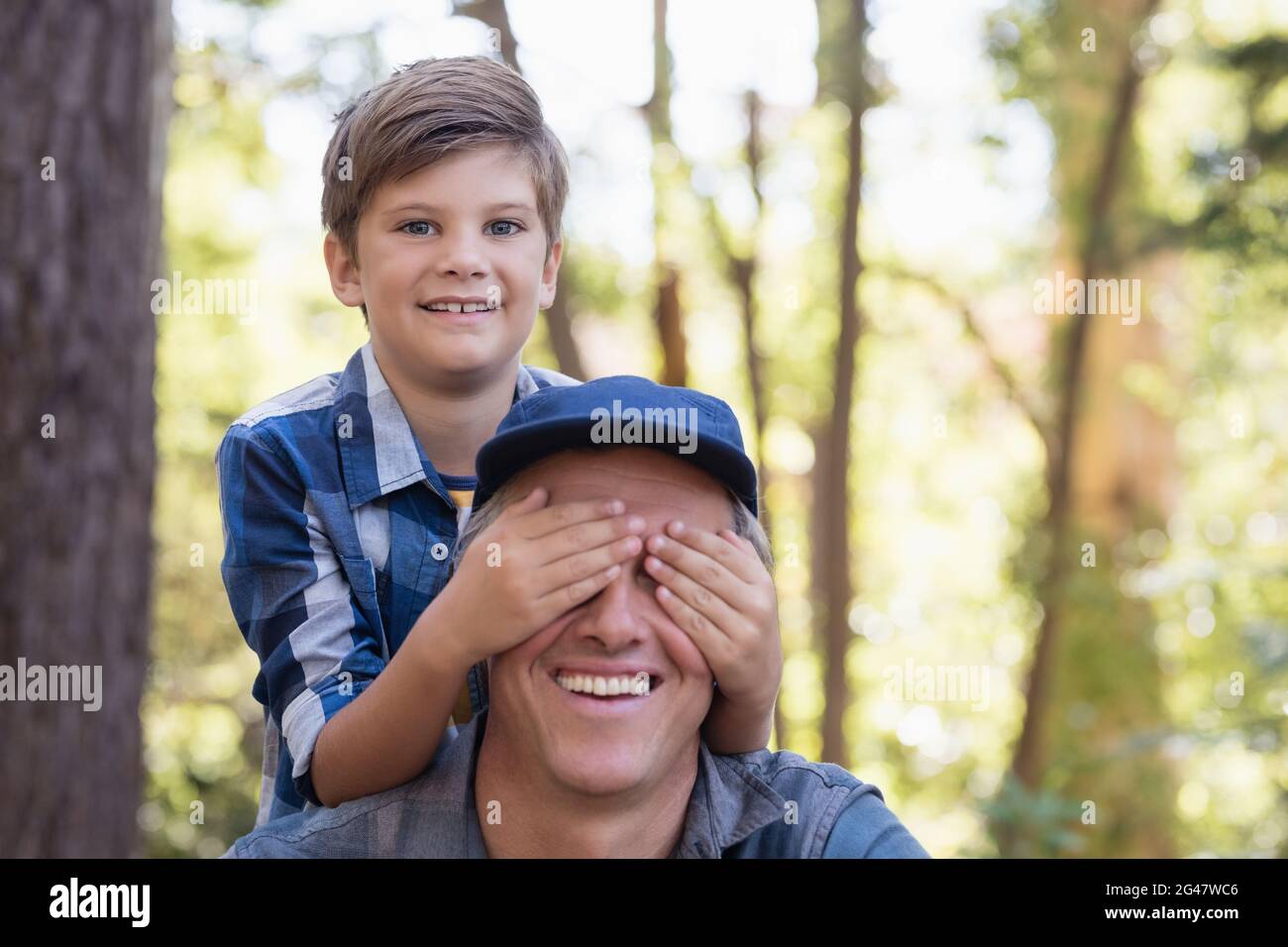 Portrait of boy covering fathers eyes Stock Photo - Alamy