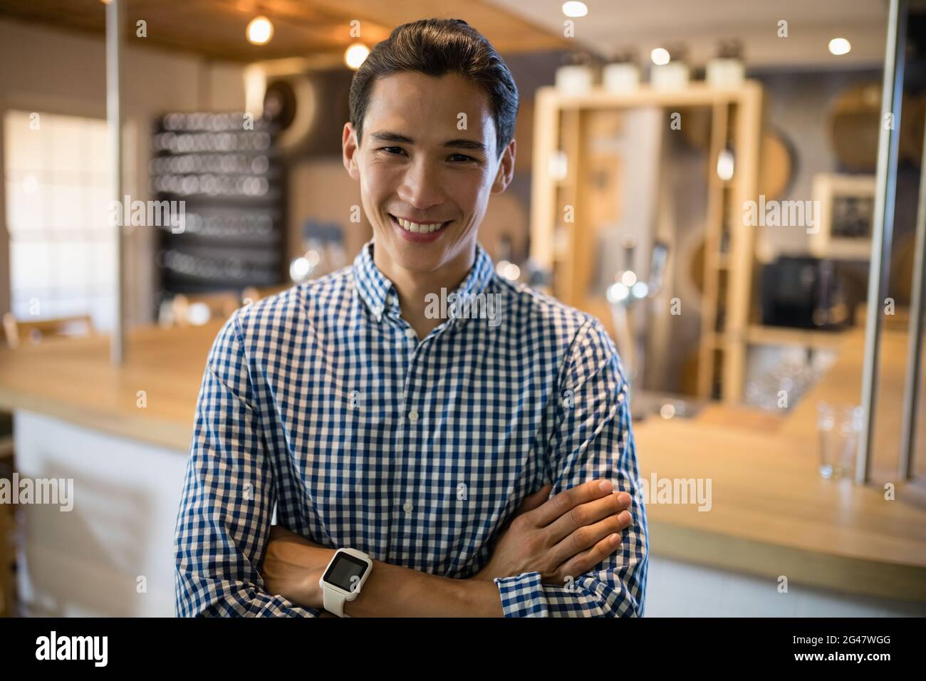 Smiling man standing with arms crossed at counter in restaurant Stock ...