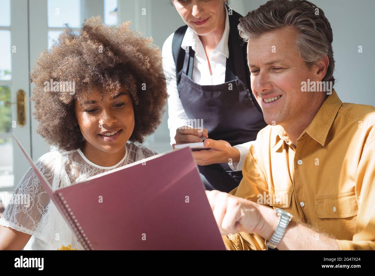 Couple placing order to waitress Stock Photo - Alamy