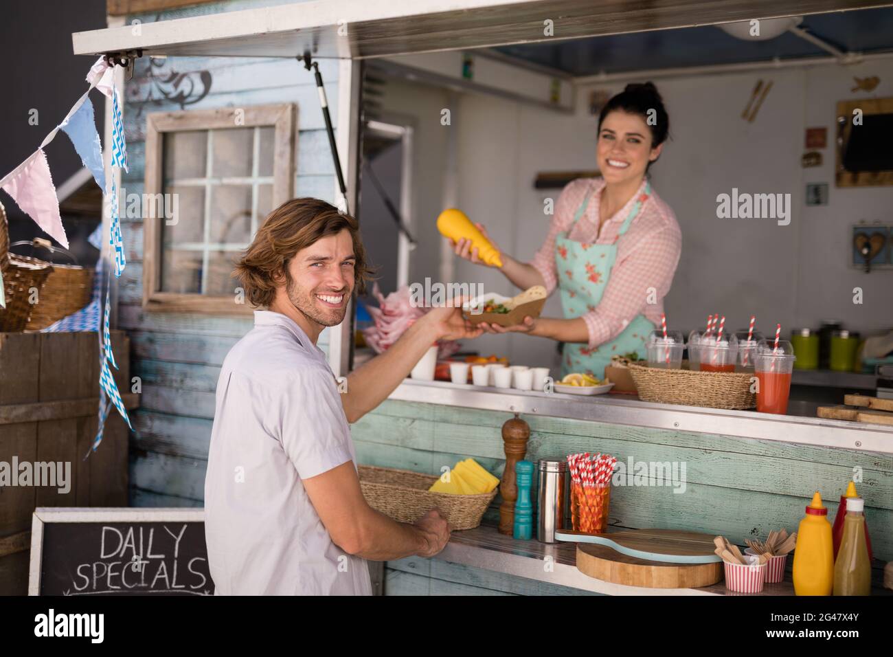 Smiling waitress giving wrap to customer at counter Stock Photo - Alamy