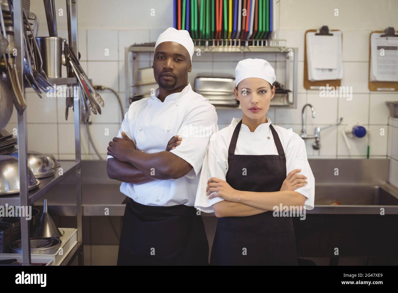 Two chefs standing with arms crossed in the commercial kitchen Stock ...