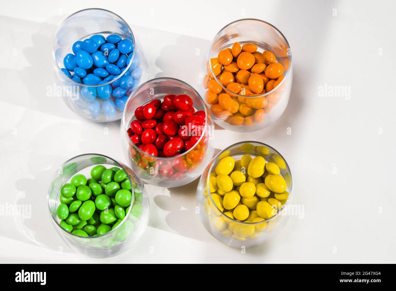 Top view of glasses with colorful sweet candies isolated on white ...