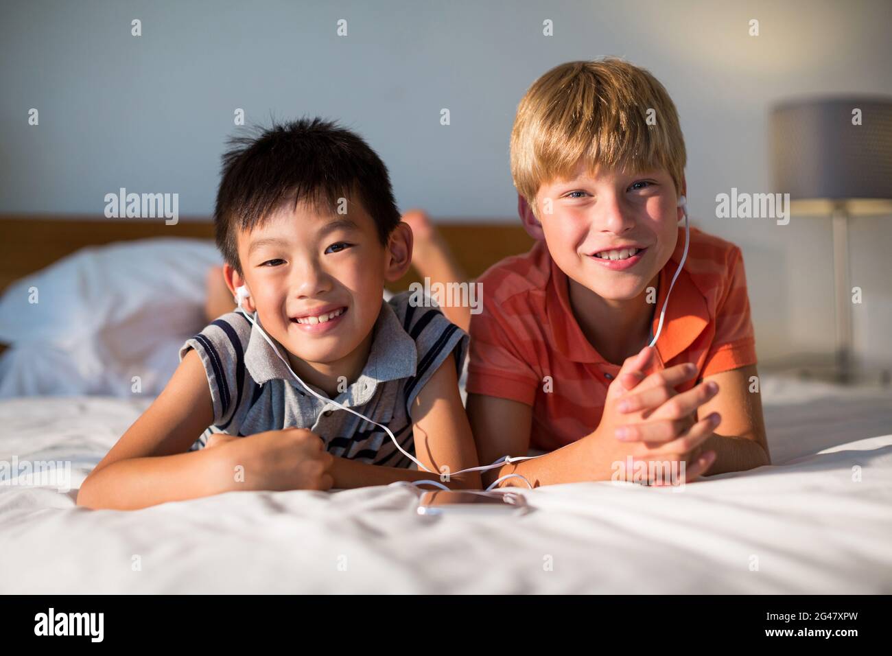 Portrait of siblings listening to music on mobile phone Stock Photo - Alamy