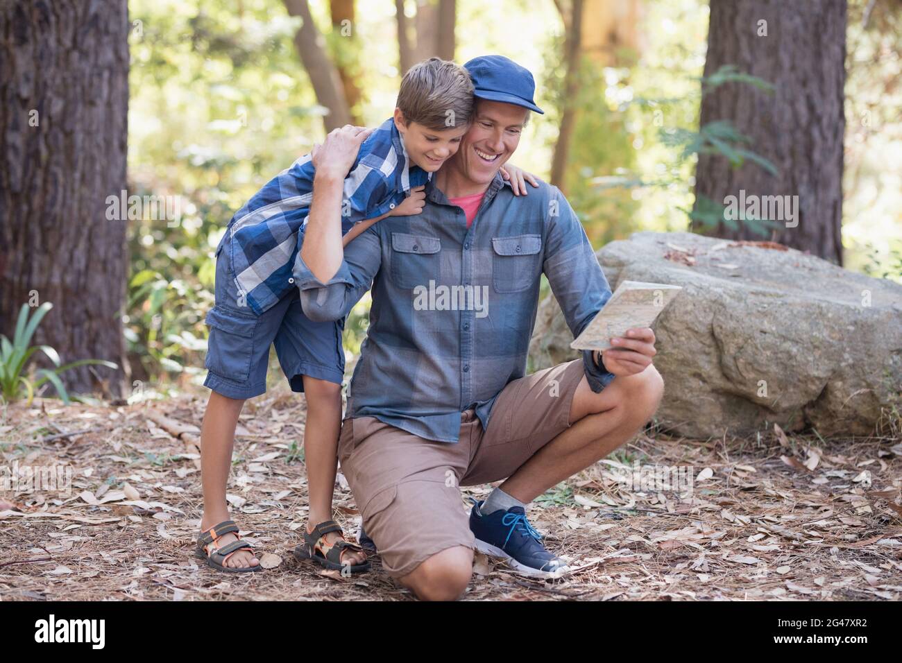 Father and son reading map while hiking in forest Stock Photo - Alamy