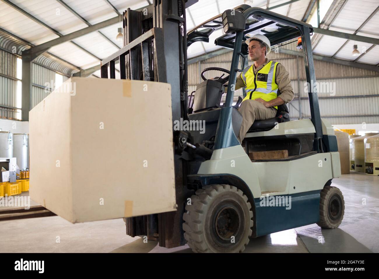Worker carrying package with forklift Stock Photo - Alamy