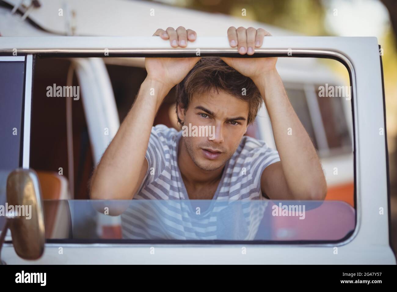 Portrait of serious young man leaning on van Stock Photo - Alamy