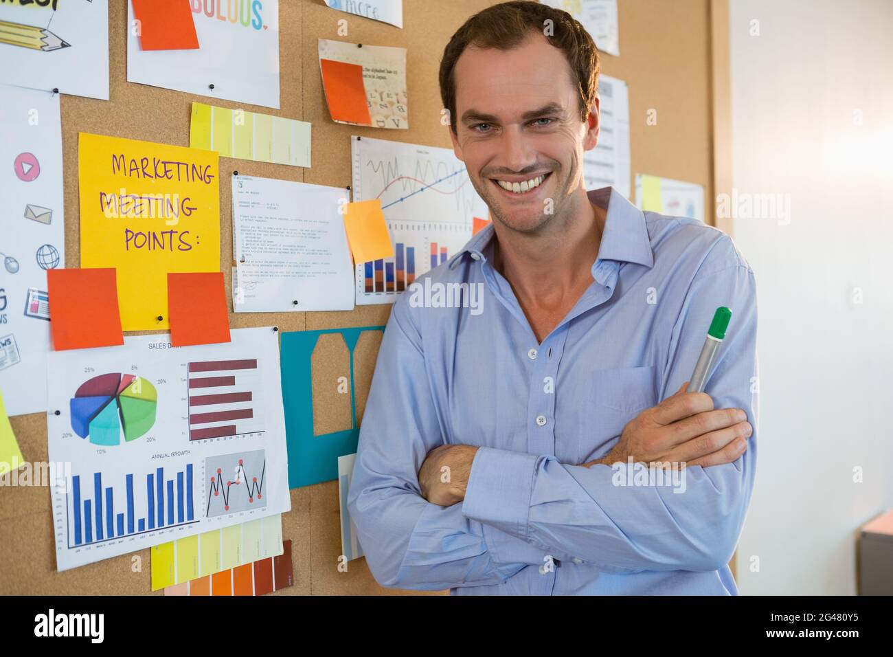 Male executive standing with arms crossed Stock Photo - Alamy