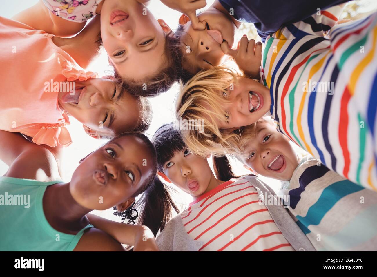 Schoolkids forming huddle Stock Photo - Alamy