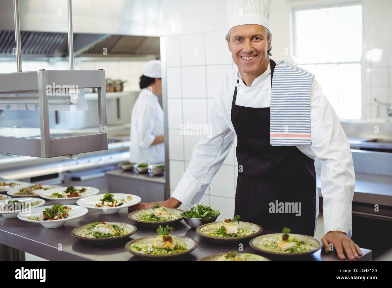 Portrait of happy chef with appetizer plates at order station Stock ...