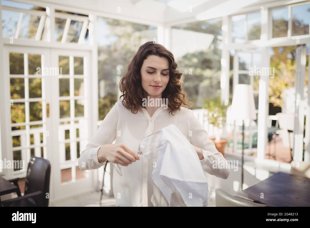 Beautiful waitress cleaning wine glass with napkin Stock Photo - Alamy