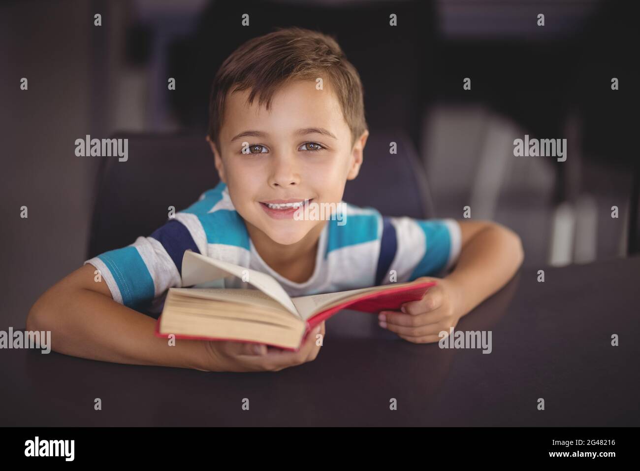 Schoolboy reading in library hi-res stock photography and images - Alamy