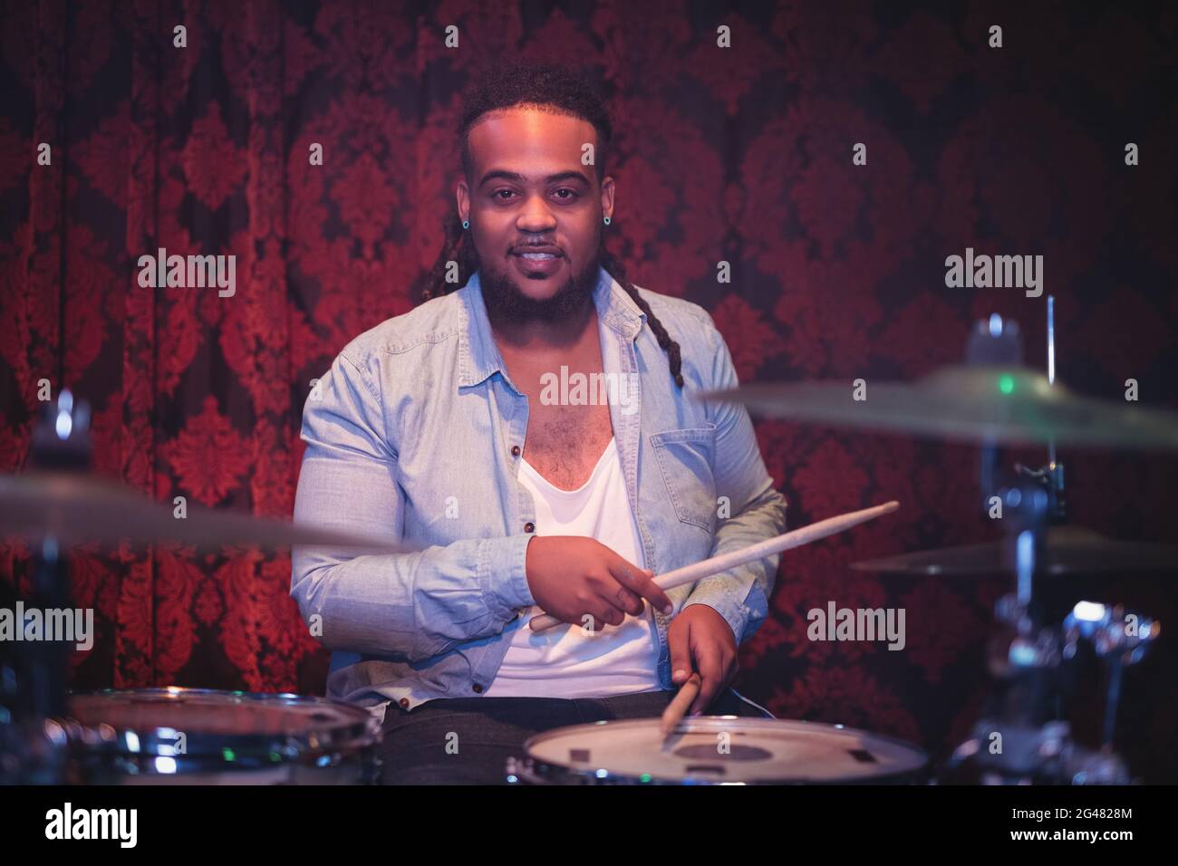 Portrait of smiling musician playing drum kit Stock Photo - Alamy