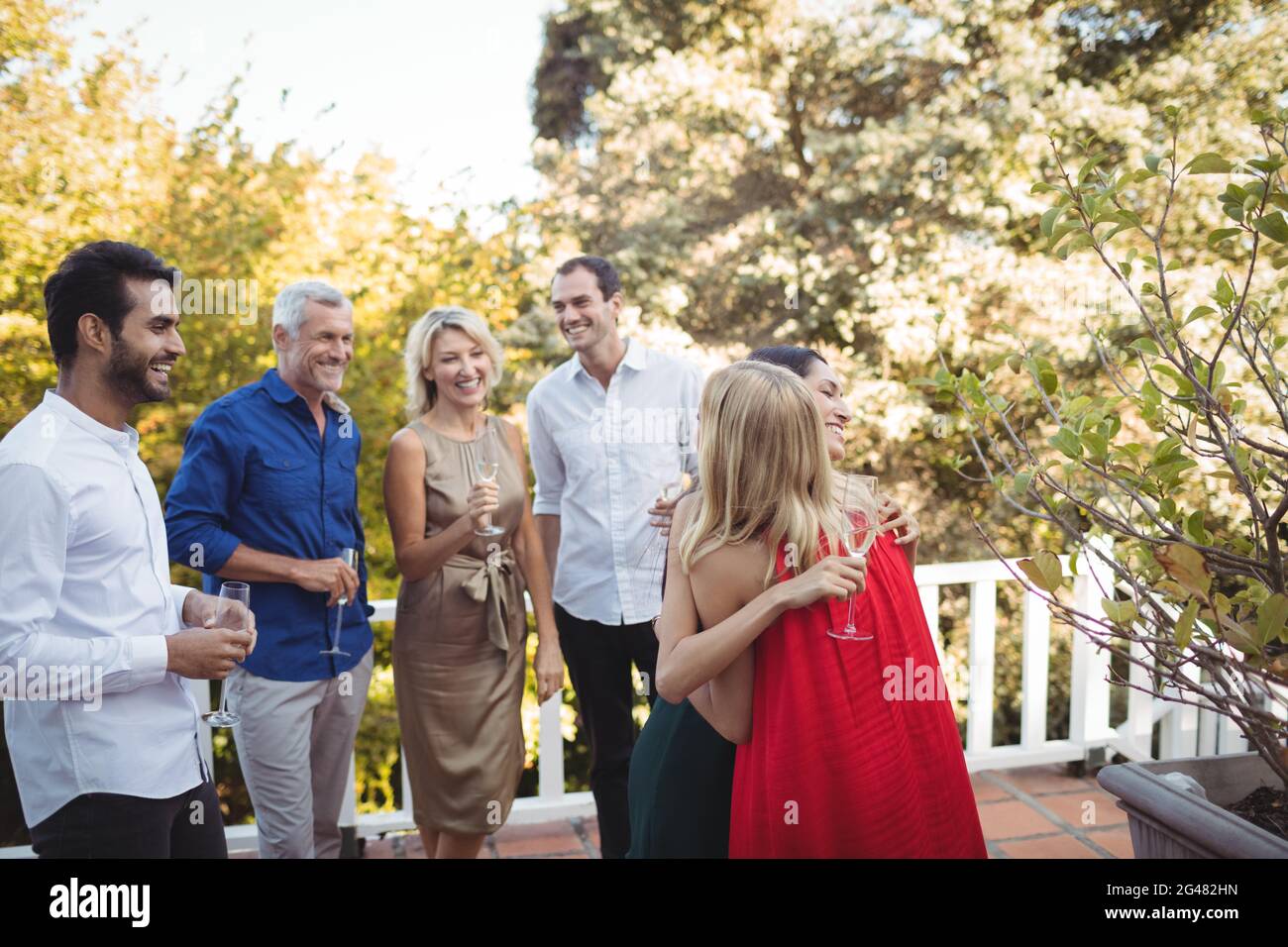 Female friends embracing each other in balcony Stock Photo - Alamy