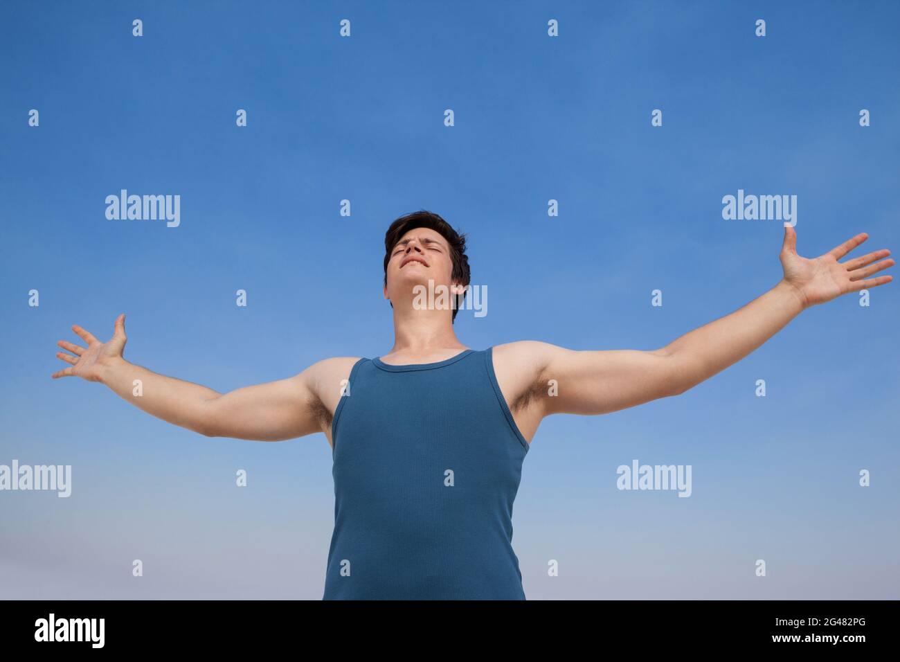 Man standing at beach with arms outstretched Stock Photo - Alamy