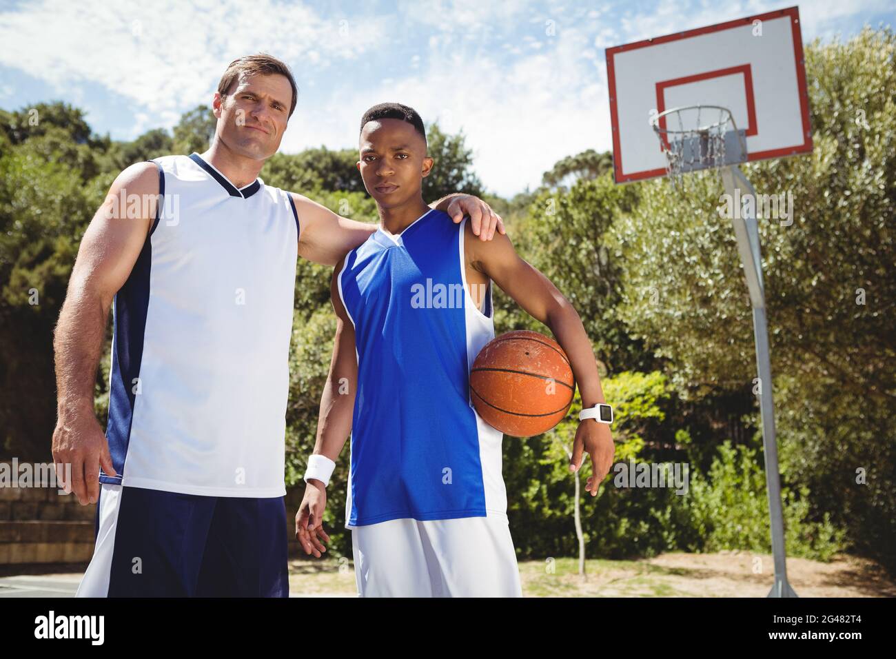Portrait of basketball player with arm around Stock Photo - Alamy