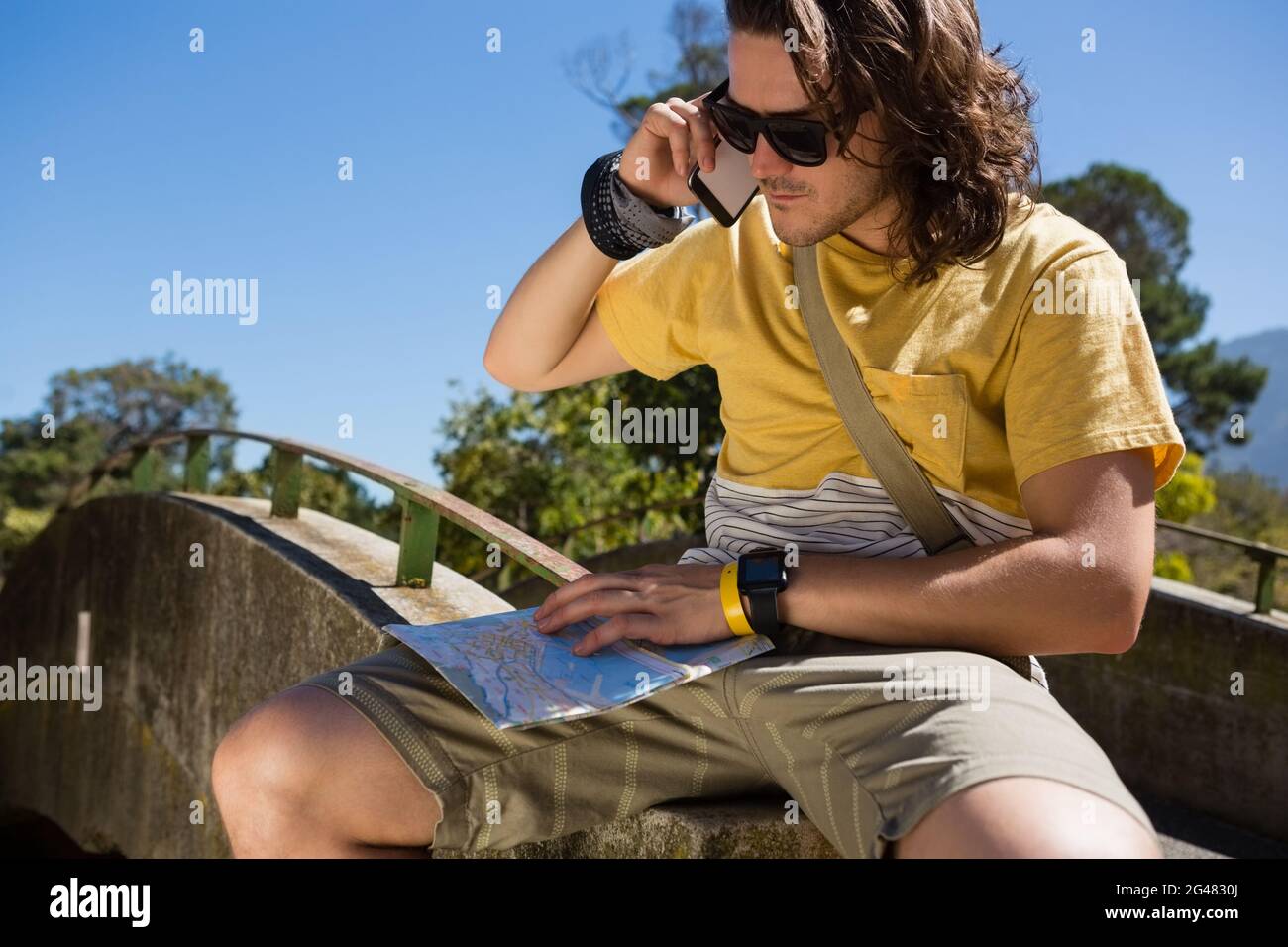 Tourist man with map talking on mobile phone Stock Photo - Alamy