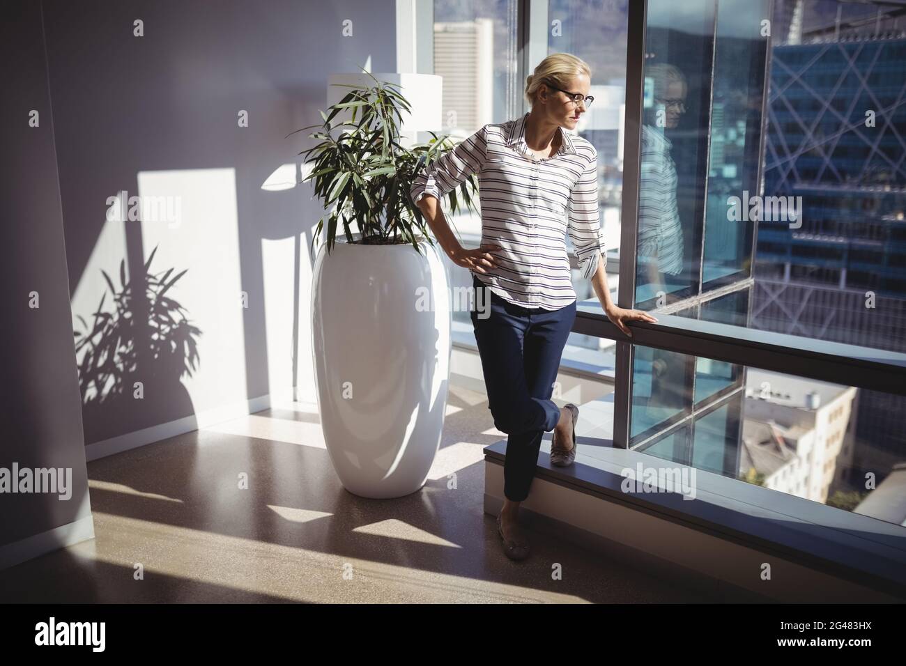 Thoughtful executive standing in corridor Stock Photo - Alamy