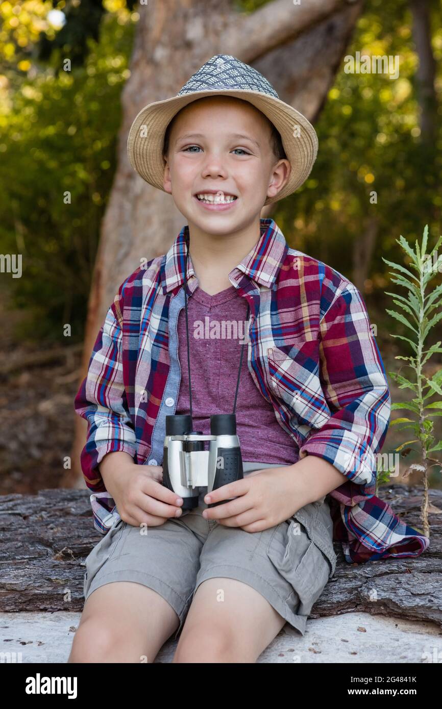 Boy sitting on fallen tree hi-res stock photography and images - Alamy