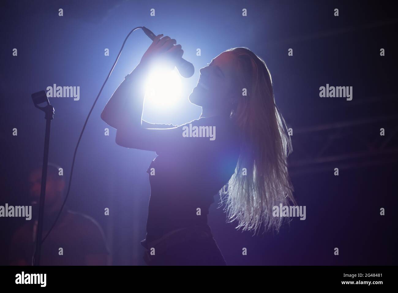 Cheerful female singer at nightclub Stock Photo - Alamy