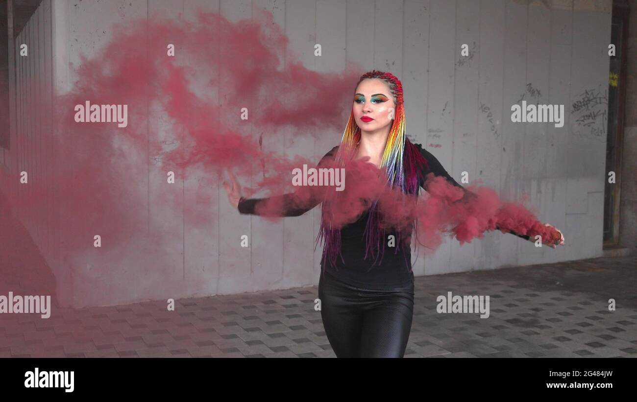 Attractive girl with multicolored braids and makeup in an black dress ...