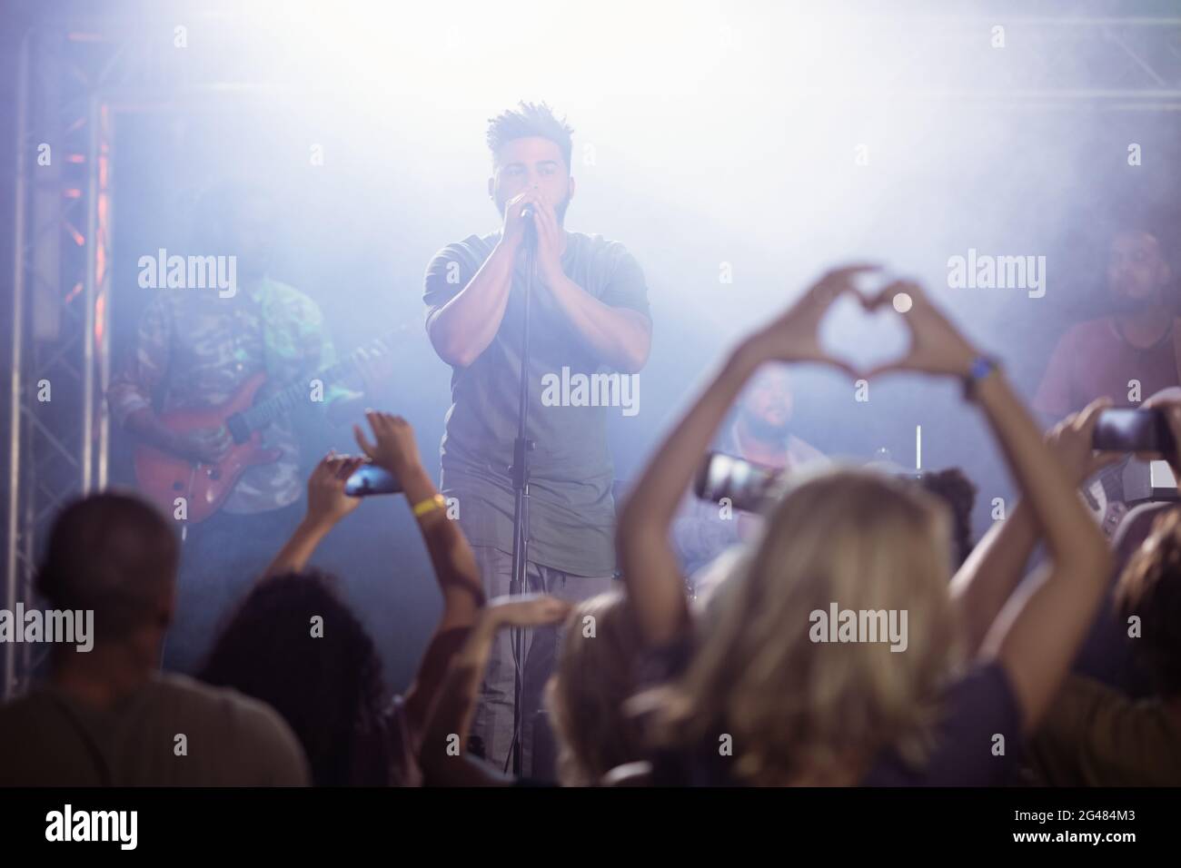 Male singer performing in front of crowd at nightclub Stock Photo - Alamy