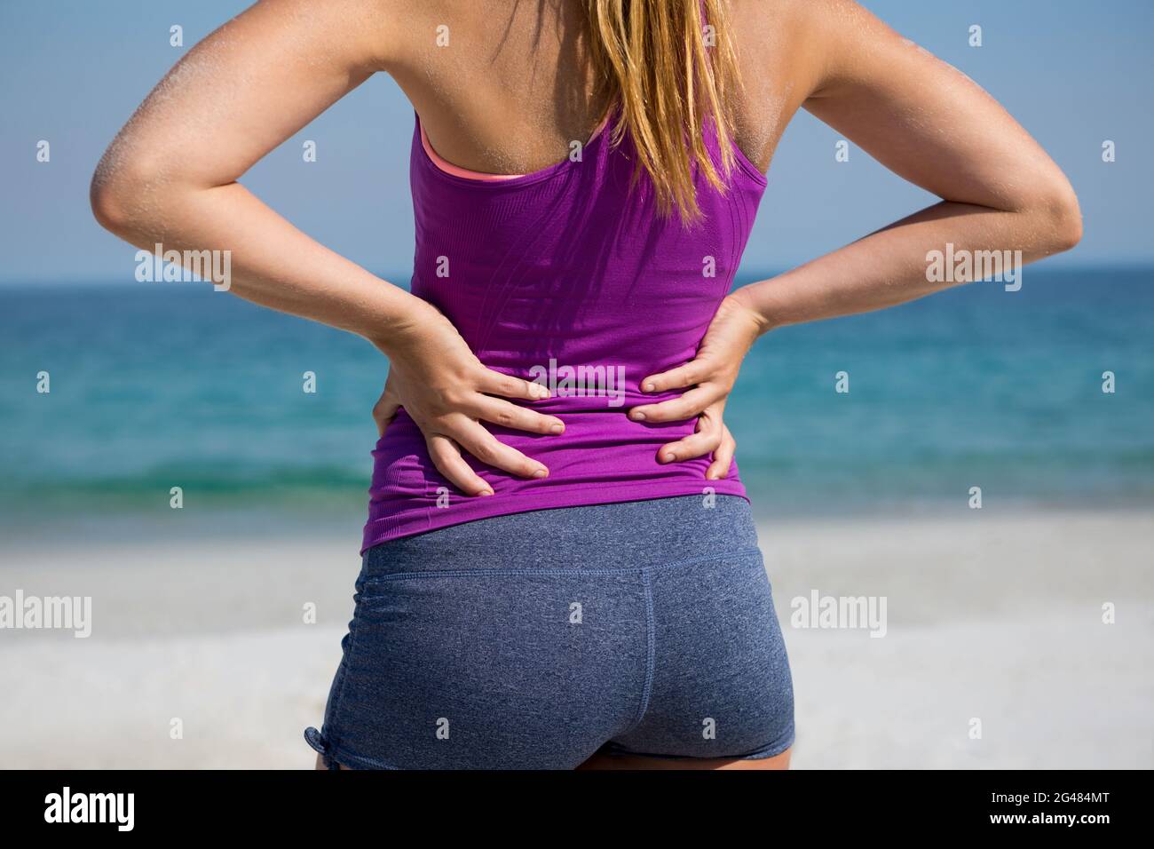 Mid section of woman standing with hands on hip at beach Stock Photo ...
