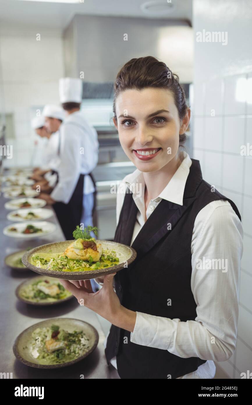 Waitress showing dishes to the camera Stock Photo - Alamy