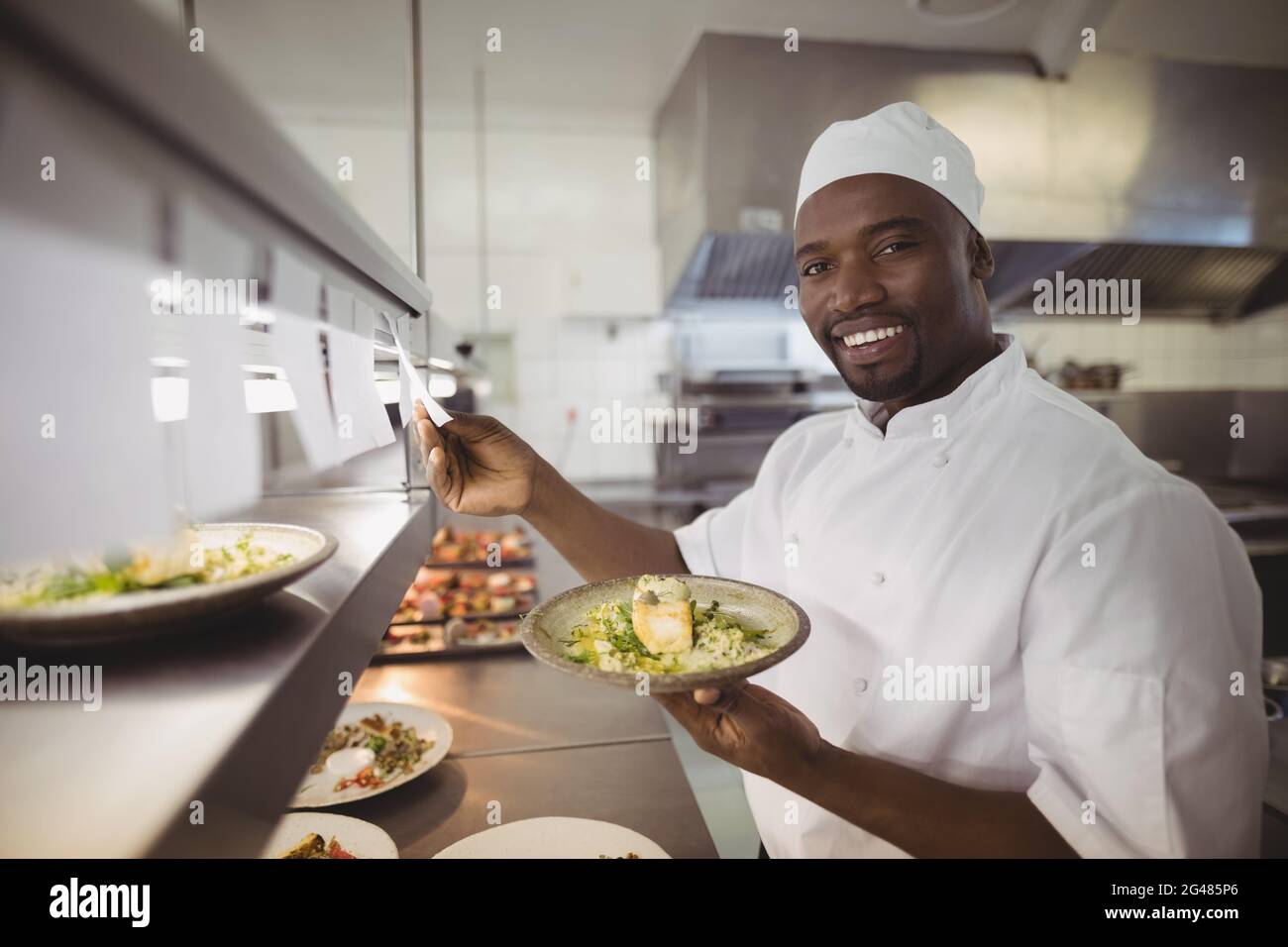 Chef standing at an order station in the commercial kitchen Stock Photo ...