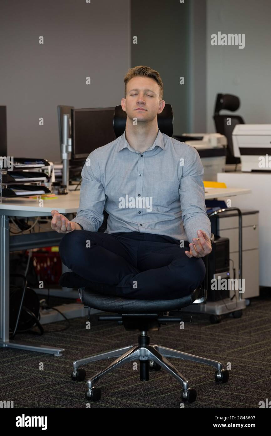 Executive meditating at desk Stock Photo - Alamy