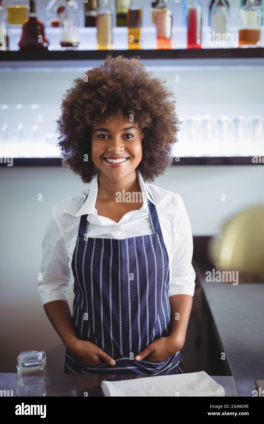 Confident waitress standing with hands in pockets at counter Stock ...