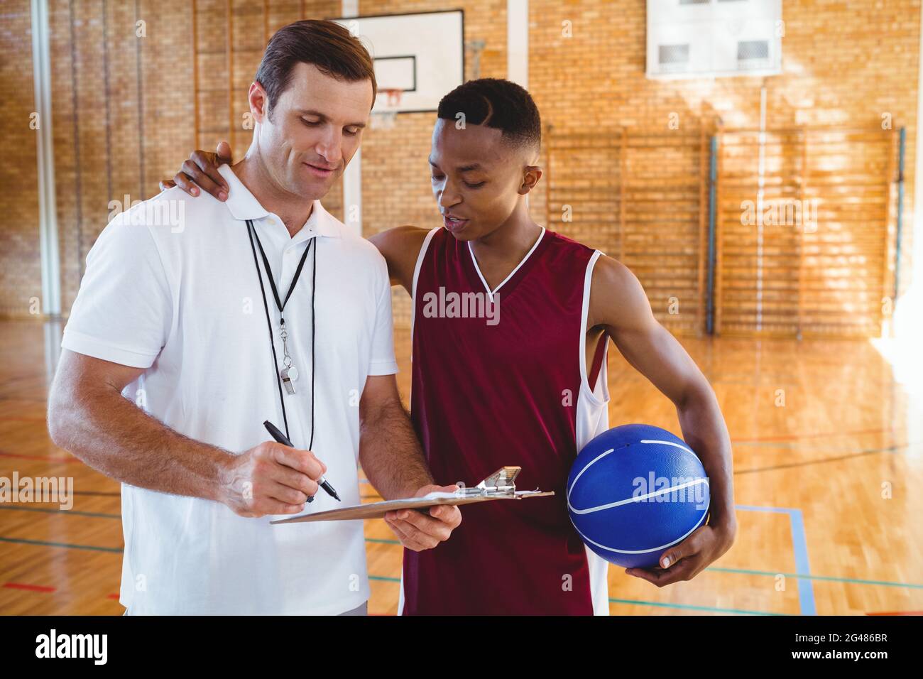 Coach discussing with basketball player Stock Photo - Alamy