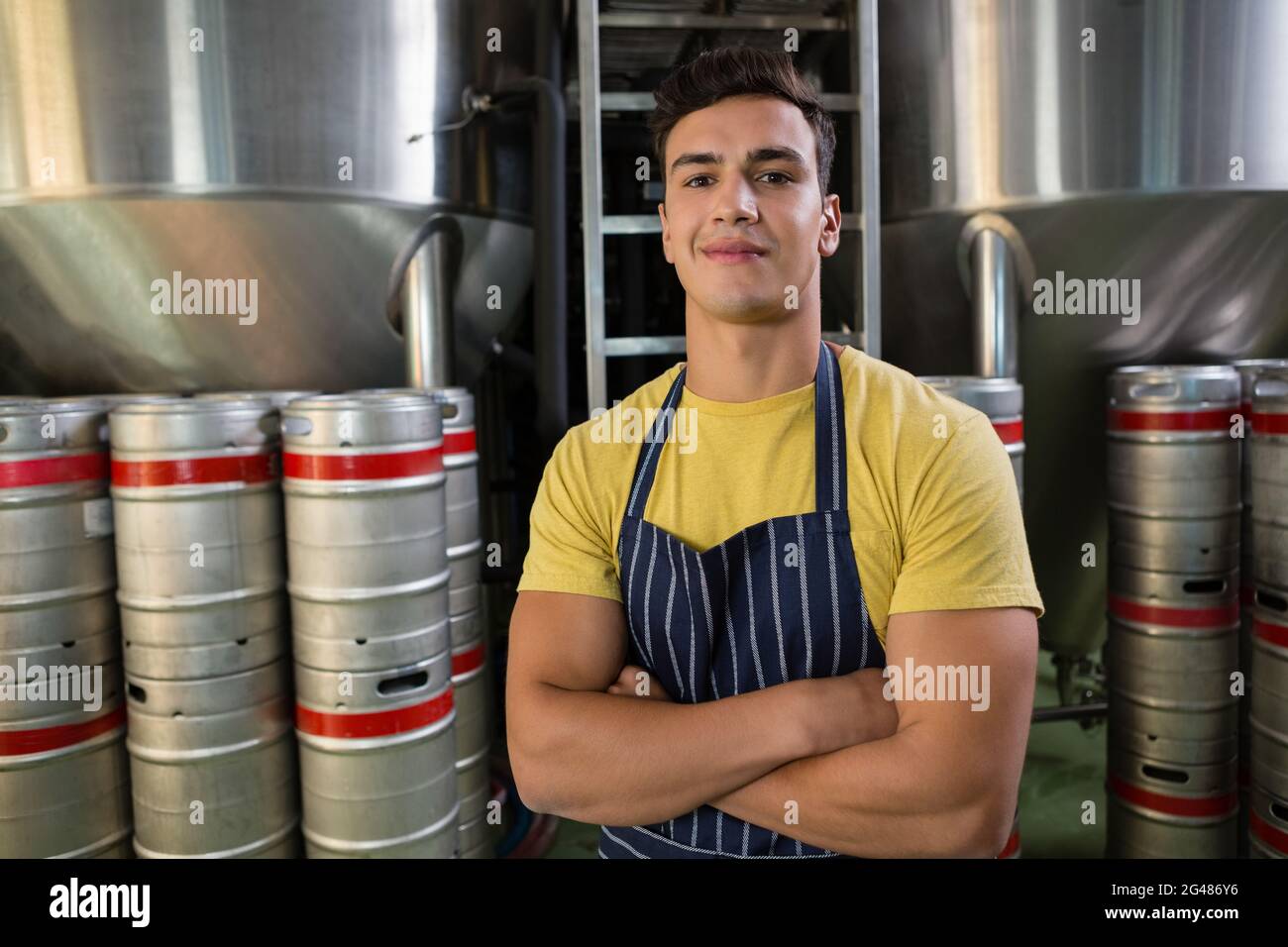 Portrait of smiling worker standing by storage tanks Stock Photo - Alamy