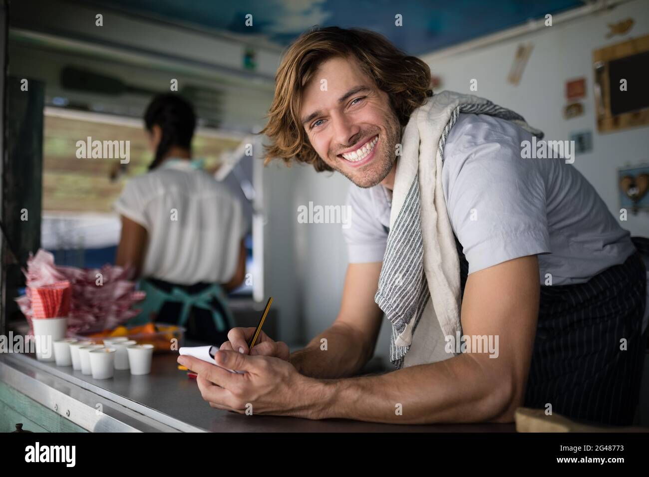 Portrait of waiter writing in notepad at counter Stock Photo - Alamy