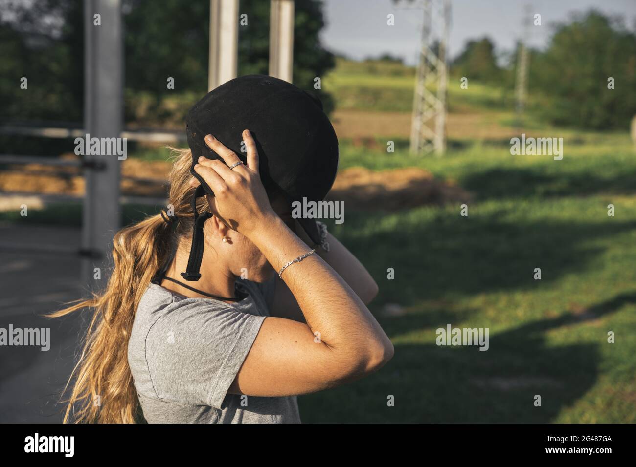 Hispanic female rider taking off her helmet Stock Photo - Alamy