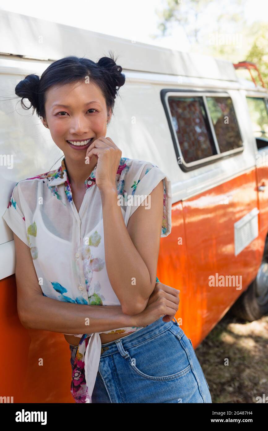 Woman leaning on camper van in the park Stock Photo - Alamy