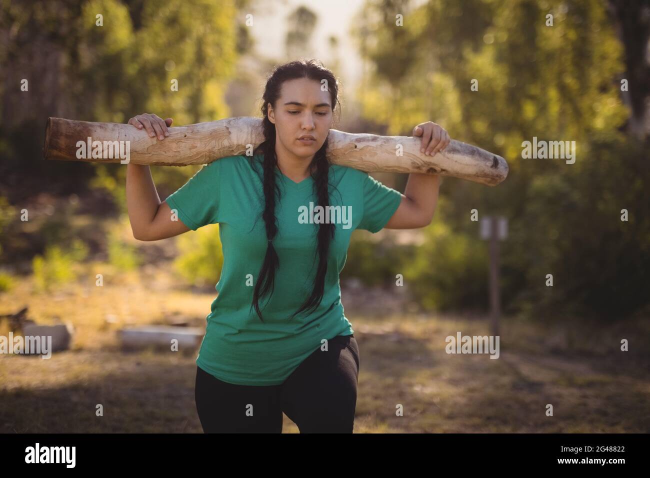 Woman carrying heavy wooden log during obstacle course Stock Photo - Alamy