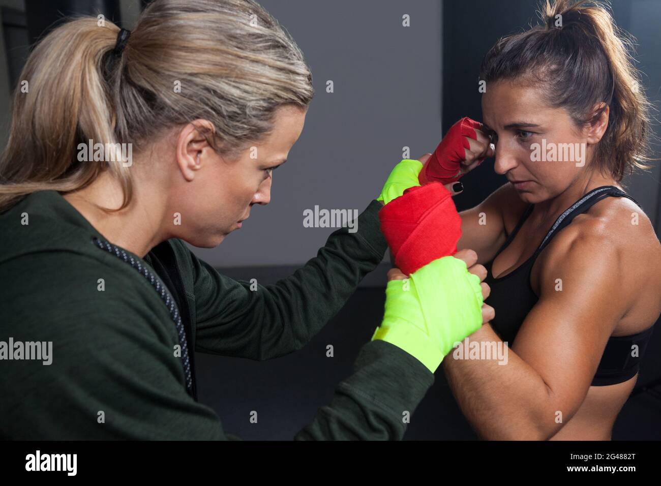 Trainer assisting woman in boxing Stock Photo - Alamy