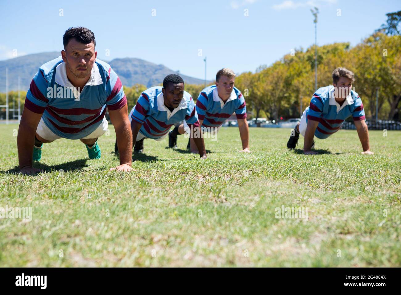 Confident rugby players doing push up at field Stock Photo - Alamy