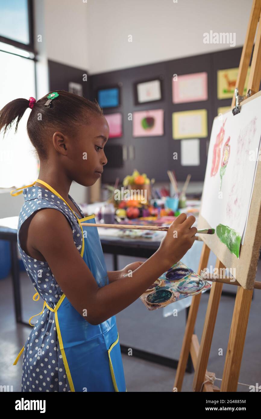 Side view of girl painting on canvas Stock Photo - Alamy