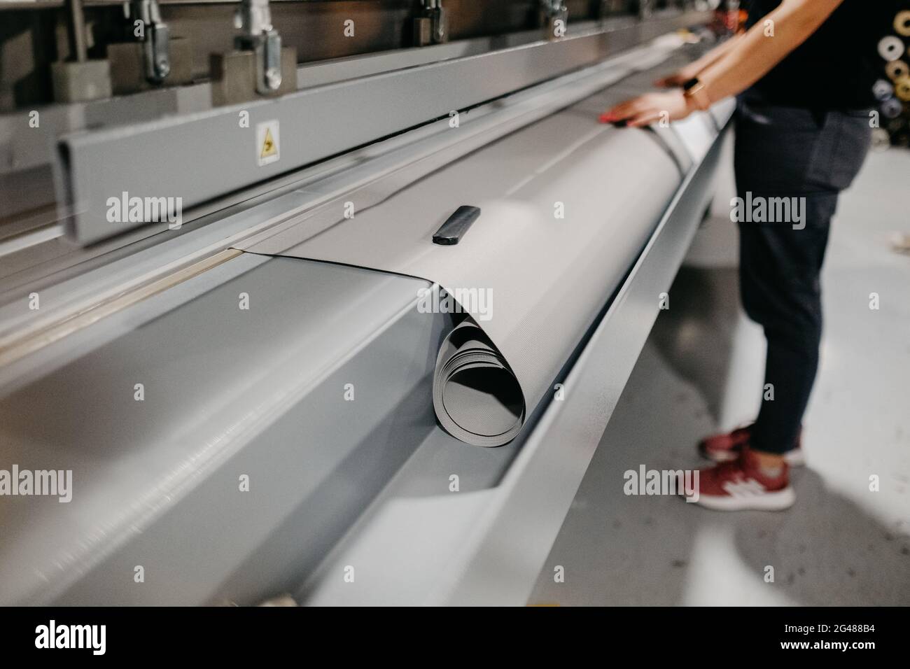 Store worker packing a wallpaper roll Stock Photo - Alamy