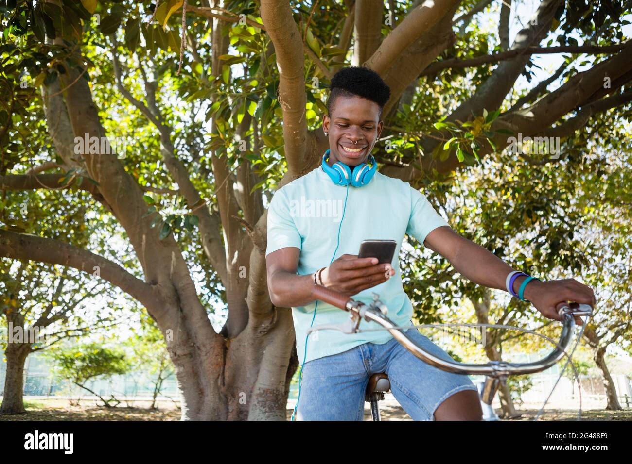 Man using mobile phone while riding his bicycle Stock Photo - Alamy