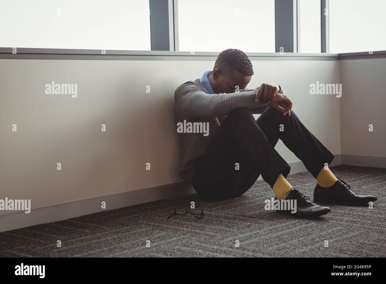 Sad executive sitting on floor Stock Photo - Alamy