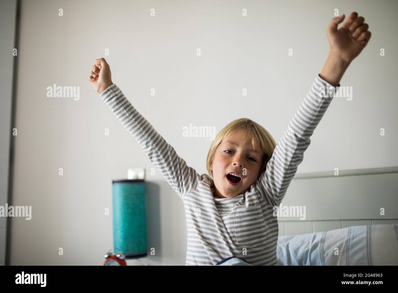 Boy yawning on bed in the bedroom at home Stock Photo - Alamy