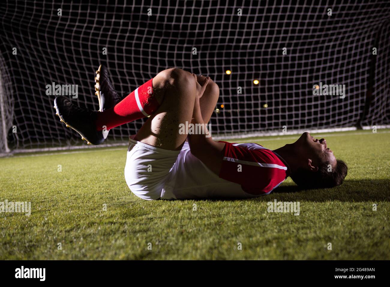 Side view of young male soccer player suffering from knee pain Stock ...