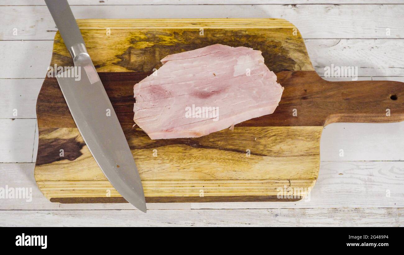Cutting organic honey ham on a wood cutting board Stock Photo - Alamy